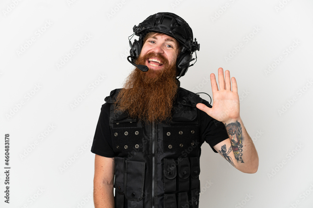 Redhead SWAT isolated on white background saluting with hand with happy ...
