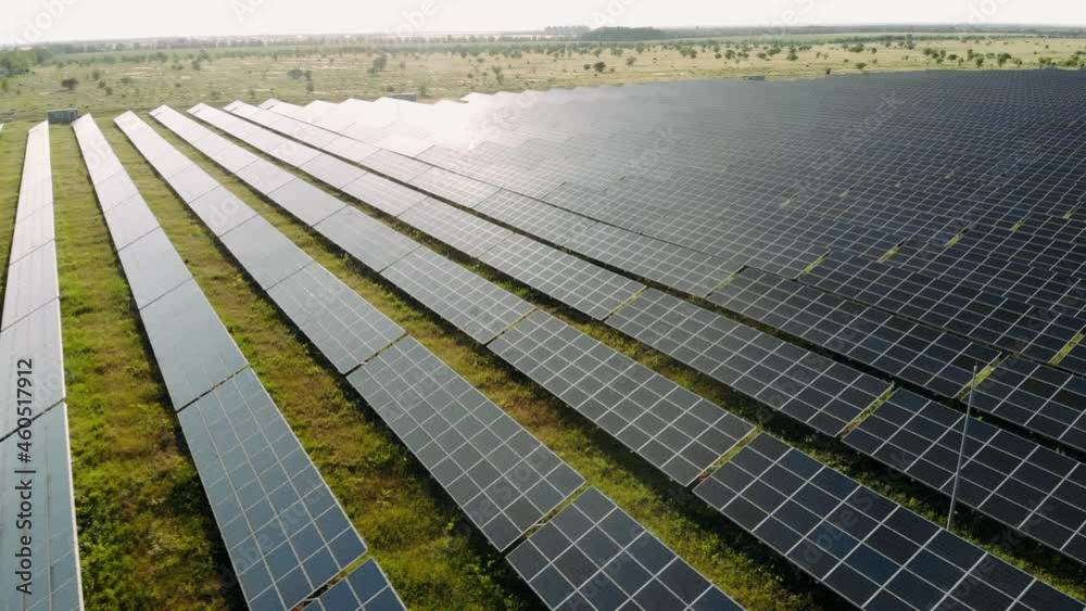 Amazing sunset aerial view of solar panels stand in a row in the fields ...