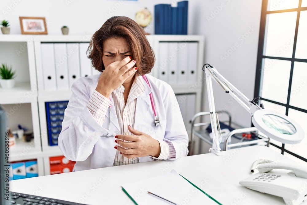 Middle age hispanic woman wearing doctor uniform and stethoscope at the ...