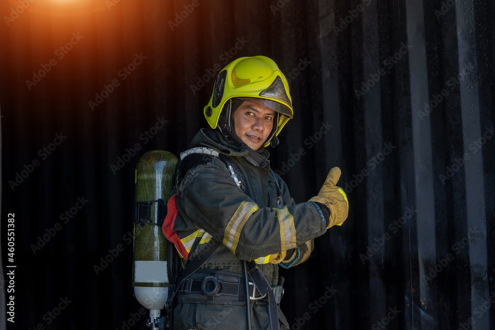 Fireman wearing firefighter turnouts holding helmet ready for emergency ...