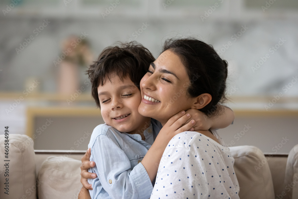 Sincere loving young indian woman cuddling cute little kid son, showing tender feelings. Happy ...