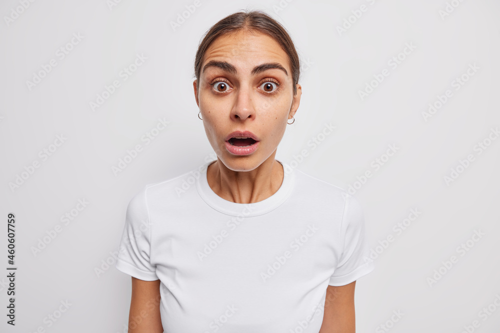 Portrait of shocked scared dark haired woman holds breath cannot ...