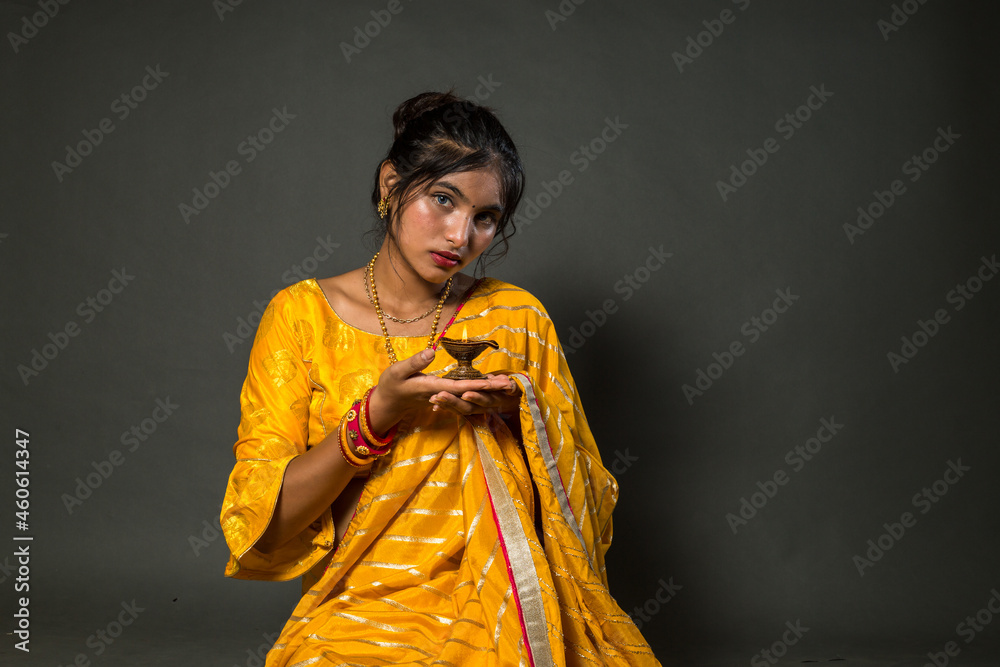 Beautiful Girl in Indian saree holding diwali diya(oil lamp) on gray ...