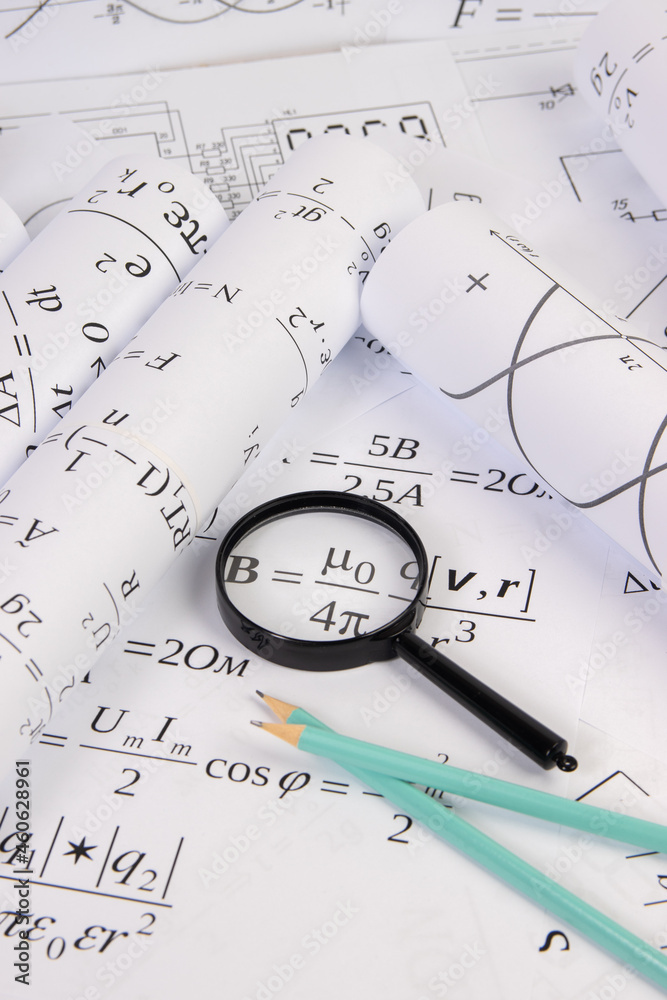 rolls of paper drawings with math electrical formulas, magnifier and ...
