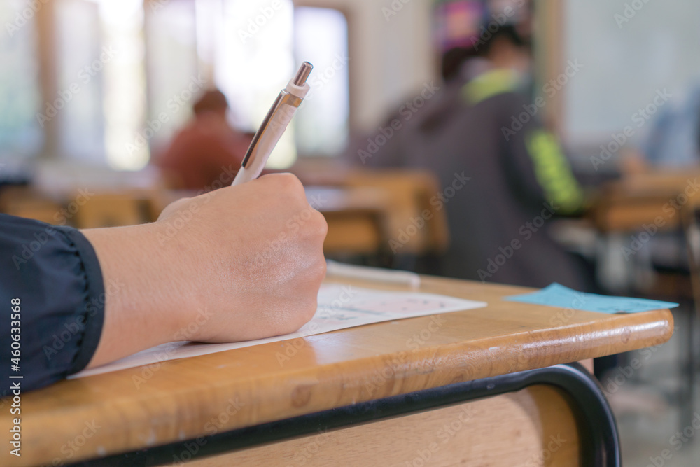 Writing on Exam Test in Classroom. Asian young student holding pencil ...