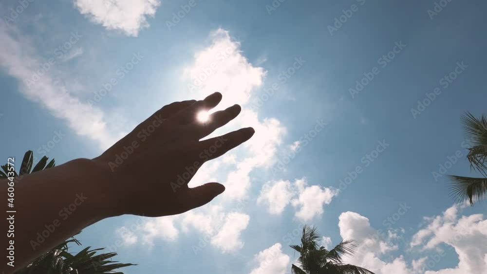 Hot summer sunlight rays pouring through human hand. Hand covering sun ...