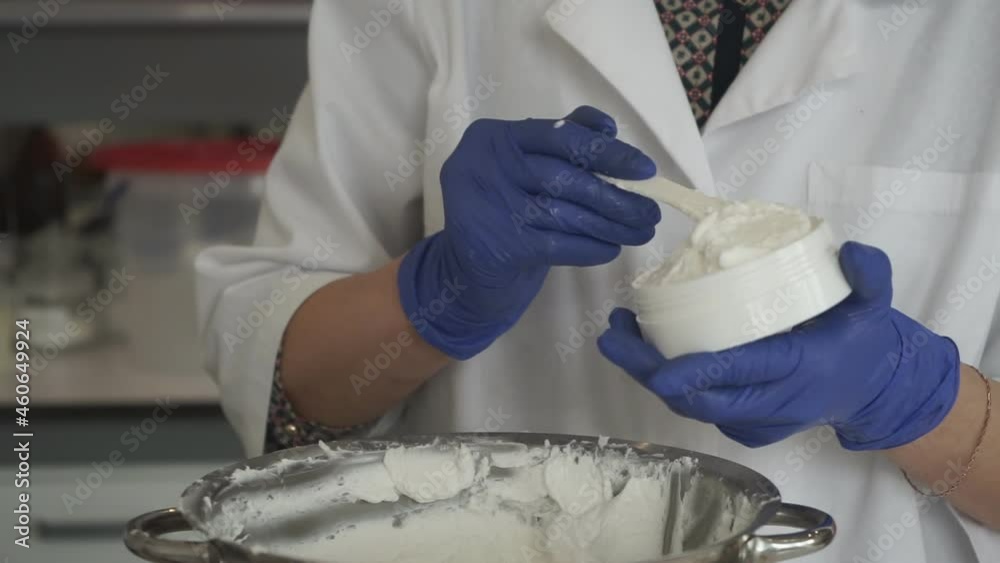 Manual filling of medical cream. A pharmaceutical plant, a worker fills ...