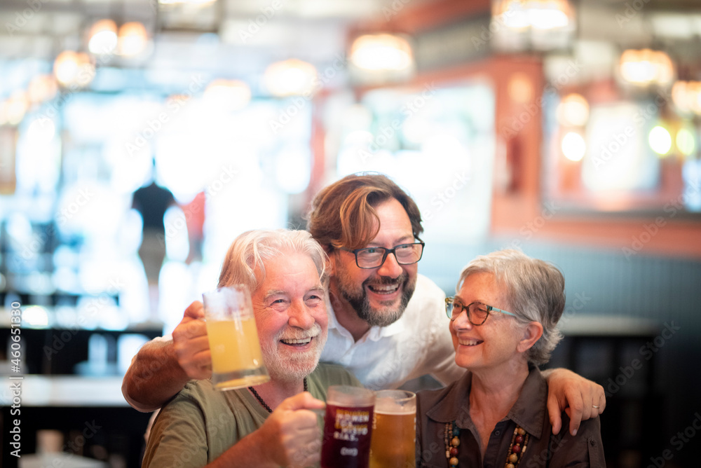Happy cheerful senior family with son having fun while drinking beer ...
