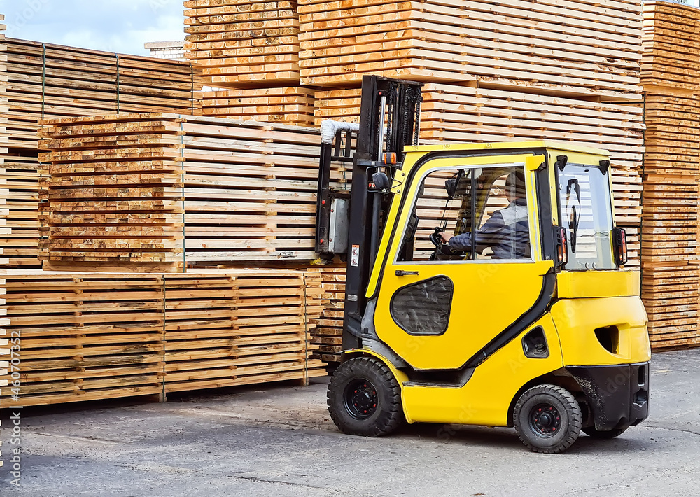 Forklift loads lumber into stacks at the finished product warehouse ...