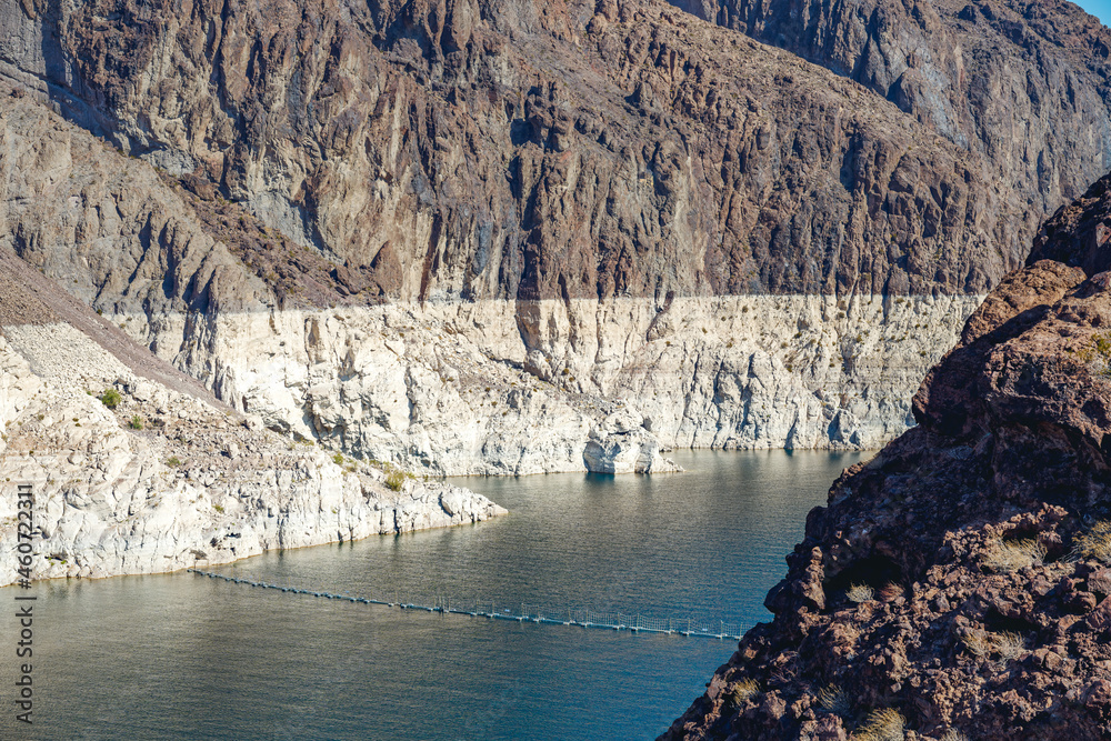 A historically low water level of Hoover Dam and Lake Mead. Dark rocks ...