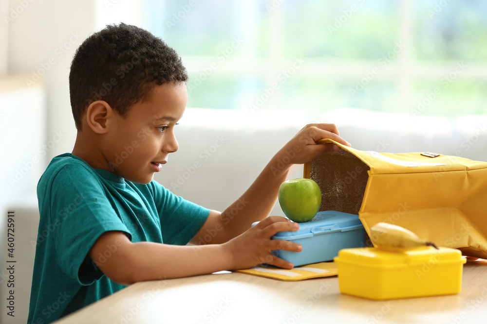 Cute little boy putting his lunch in bag Stock Photo | Adobe Stock