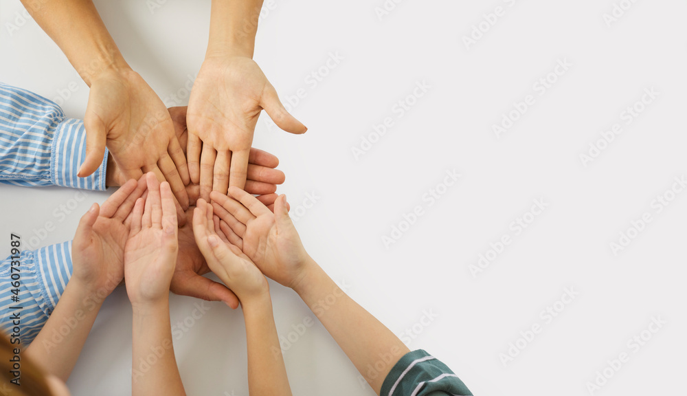 Young mother and father together holding hands of their little children ...