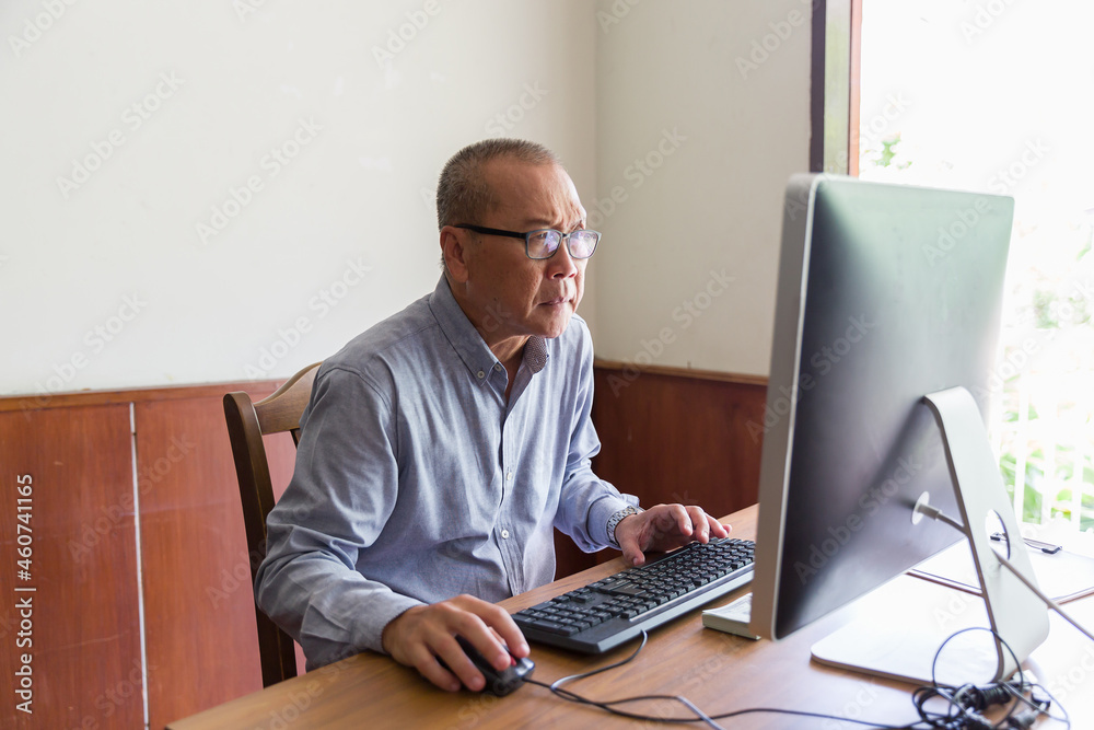 Asian senior businessman wearing glasses and sitting working with ...