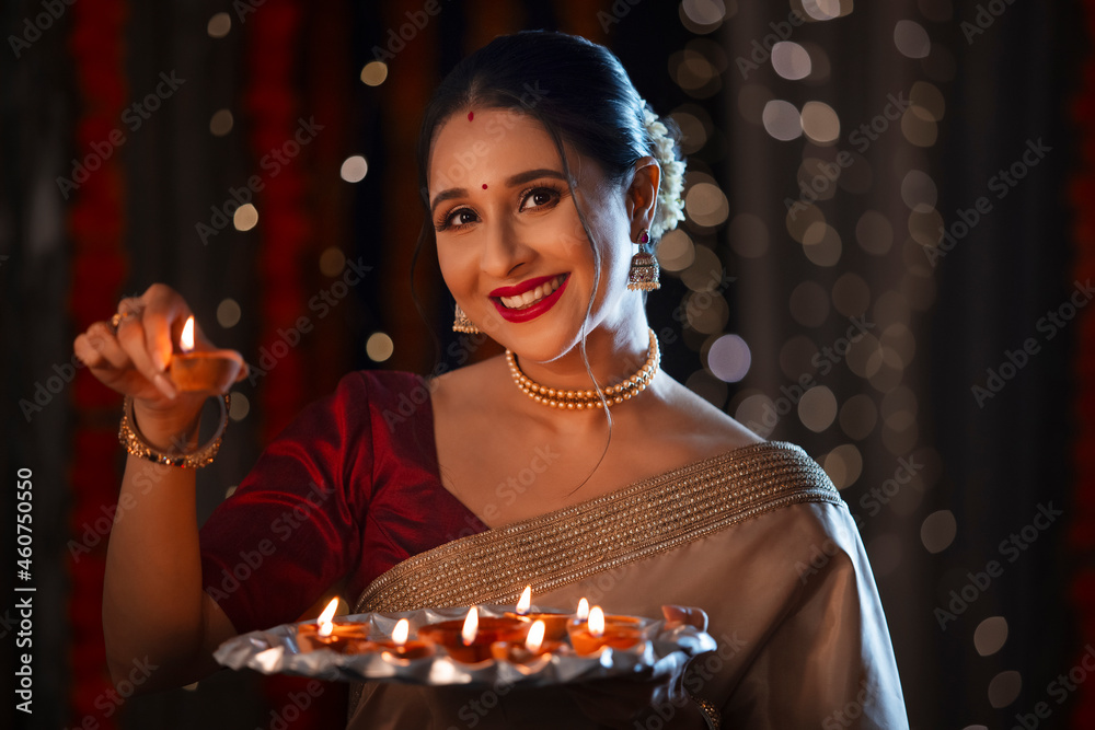 Beautiful Indian lady posing with diyas in front of camera on the ...