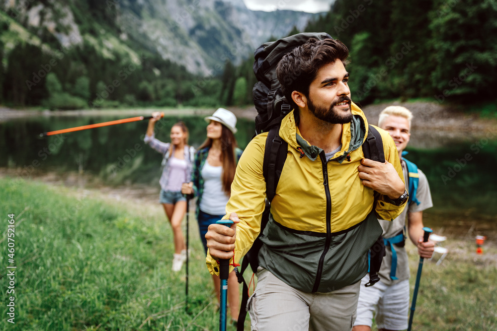 Group of friends hiking together outdoors exploring the wilderness and ...