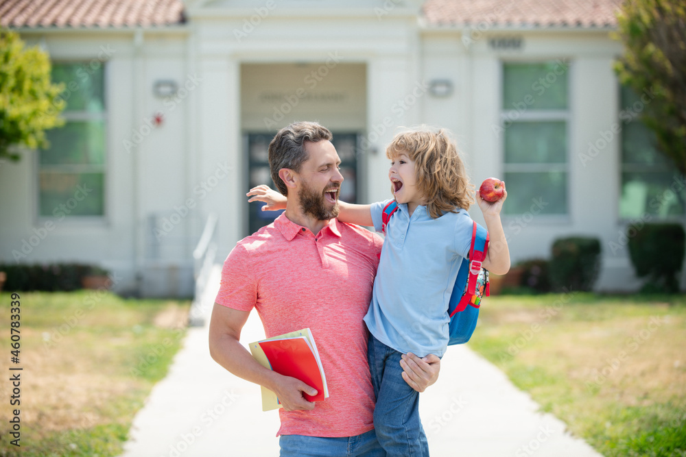 Portrait of father walking son to school. Parent and pupil of primary ...