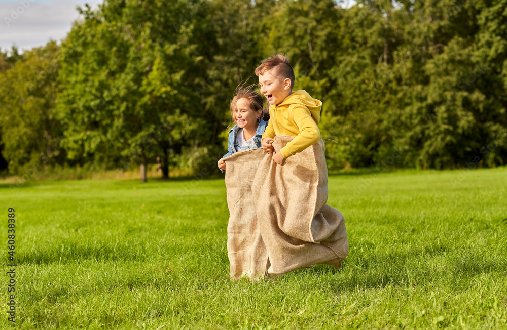 childhood, leisure and people concept - two happy children playing bag ...