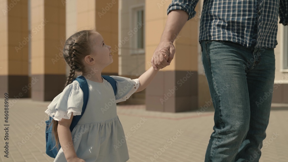 father holds happy daughter by the hand, accompany little child with ...