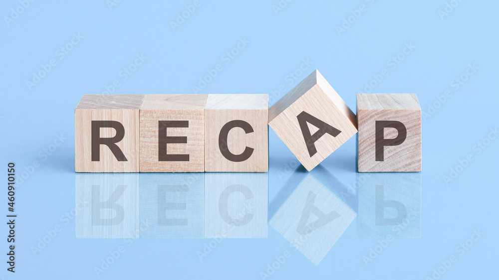recap sign made of blocks on a table with a reflective surface, blue ...