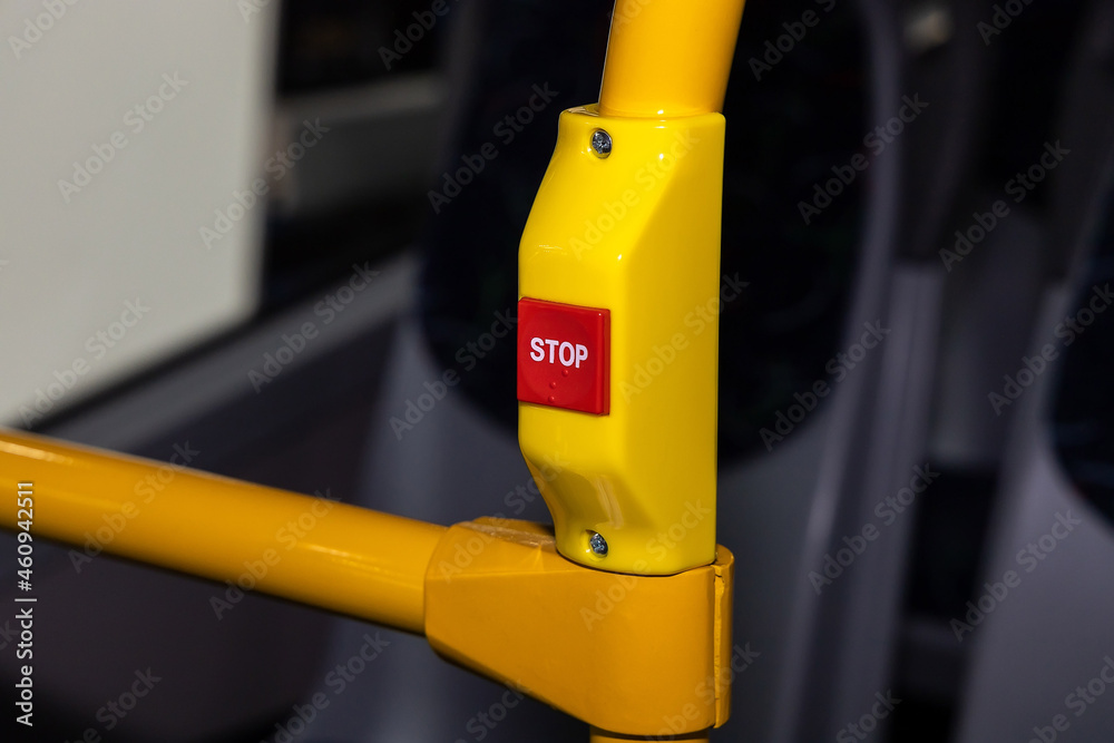 Red STOP button with Braille lettering on the bus handrail. Button to ...