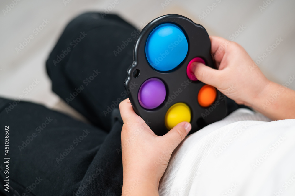 Faceless caucasian little boy plays simple dimple and relieves stress ...