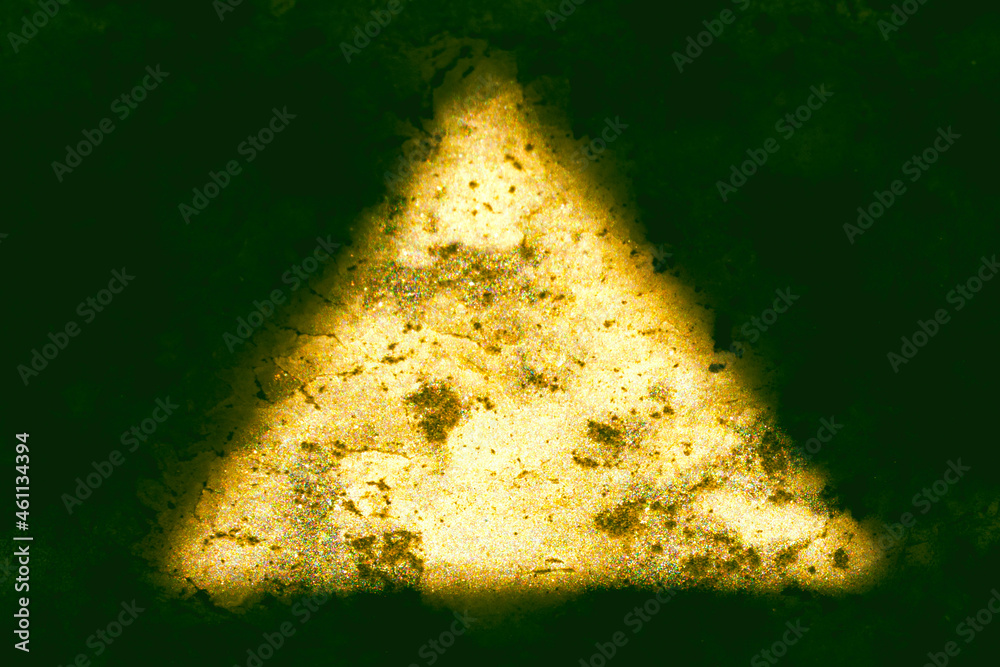 Yellow triangle shadow on a textured dark green mysterious background ...