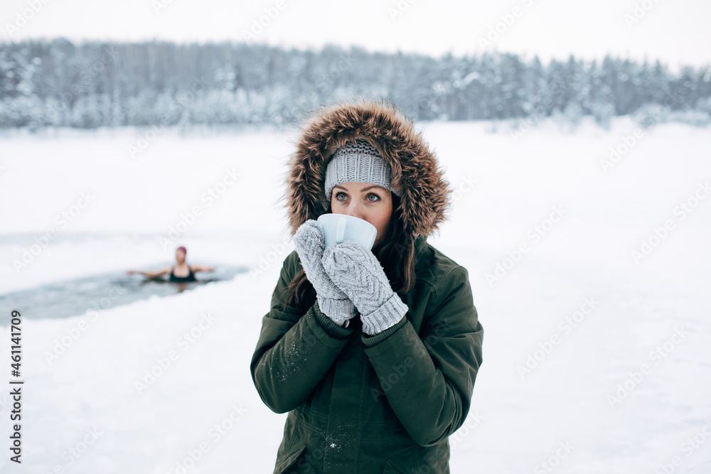 Beautiful young female smiling and drinking tea in nature Winter ...