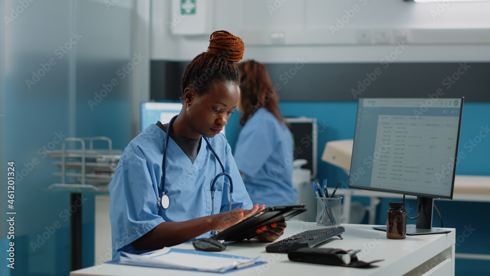 African american nurse holding digital tablet for checkup visit in ...