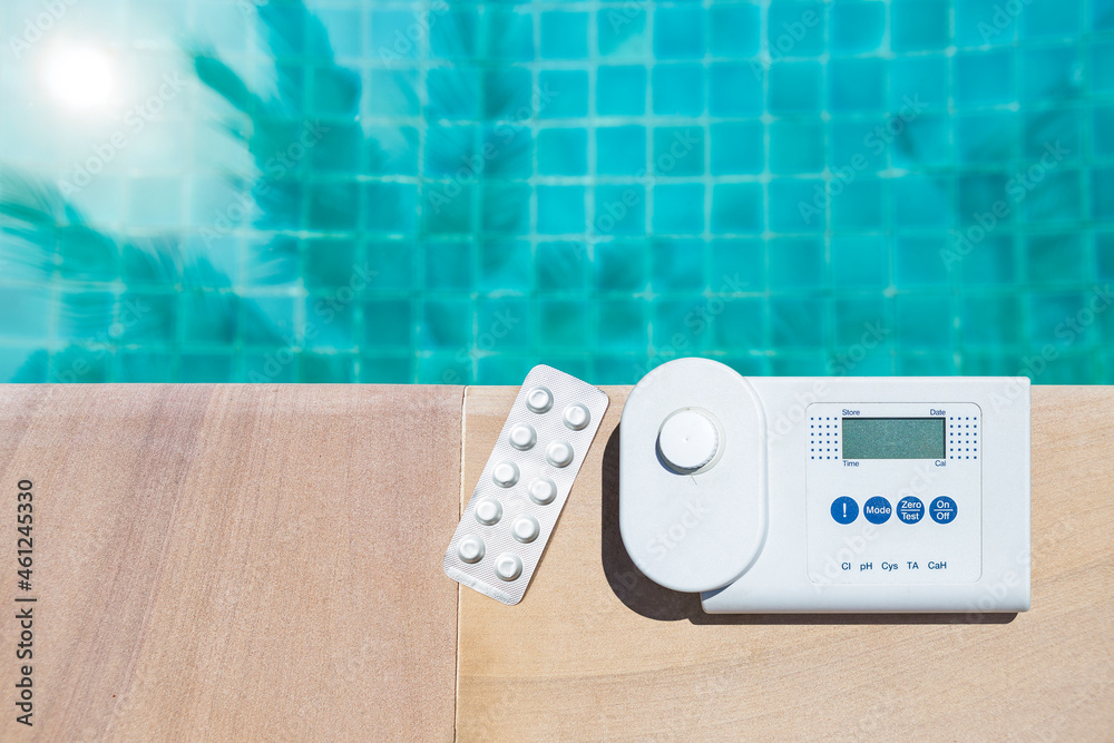 Digital water tester equipment and pool tester tablet on swimming pool ...