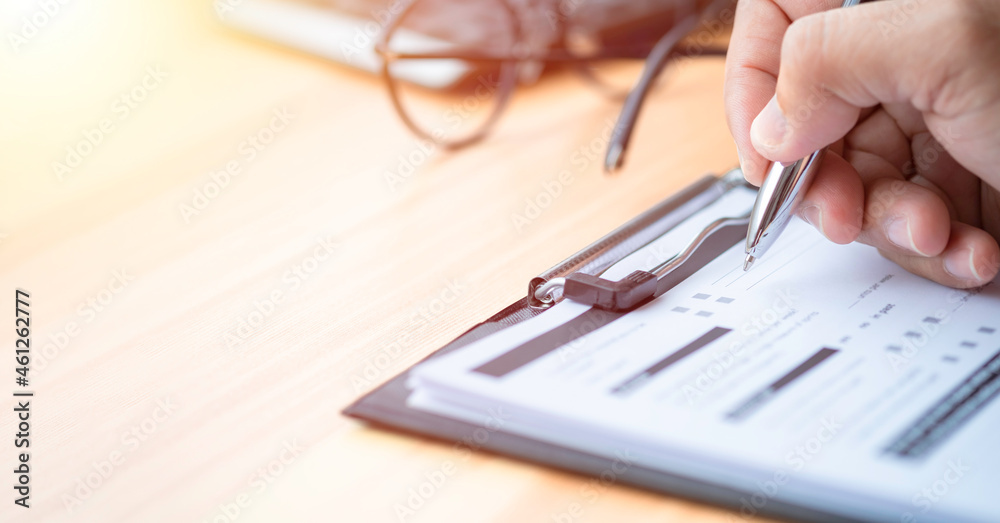 Hand using writing pen with questionnaire or paperwork survey question ...