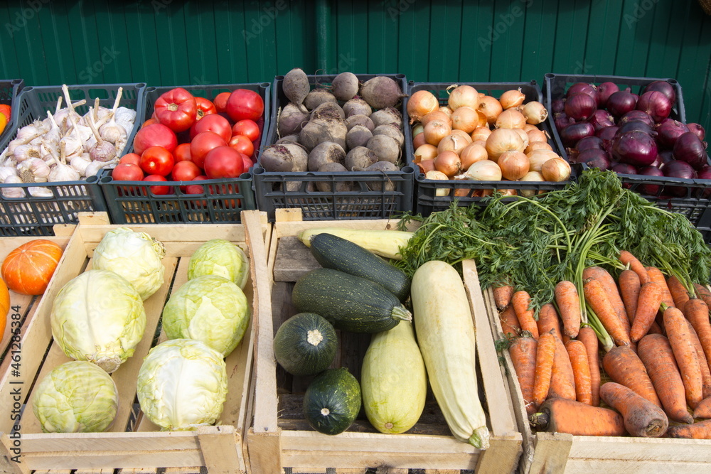 Vegetables on the market stall. The boxes contain: garlic, tomatoes ...