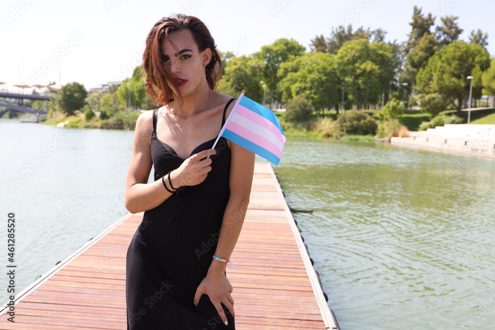young latina and transgender woman on the boards of a river pier ...