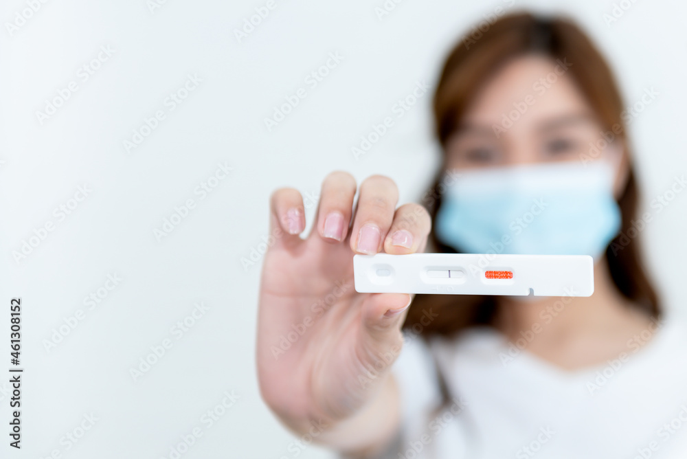 Blurred images of Woman showing test results of Rapid Antigen test ...