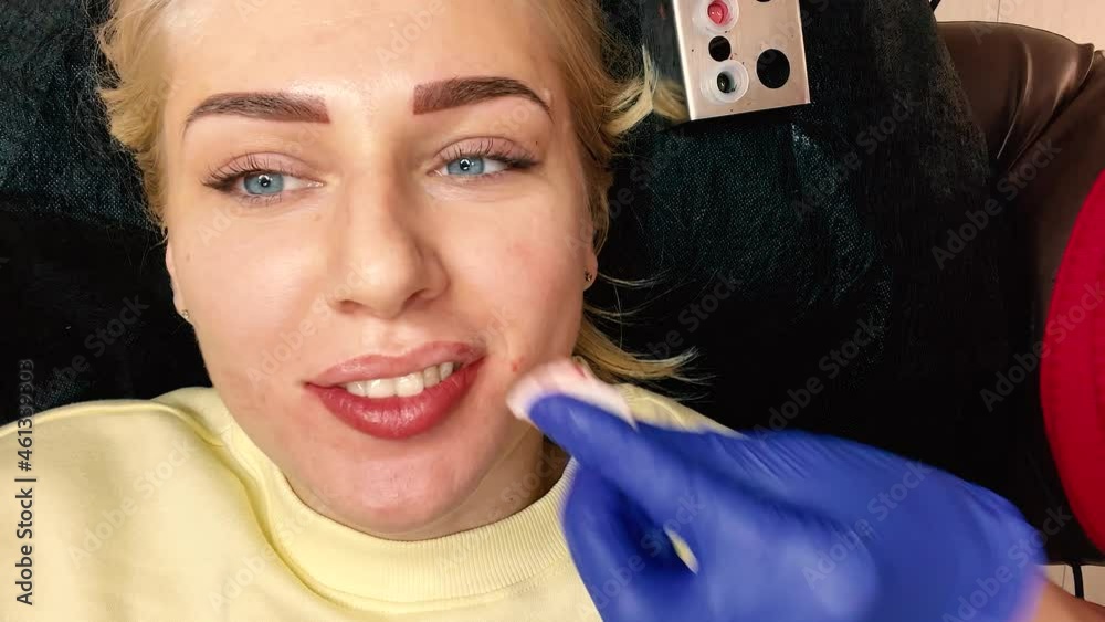 Permanent lip makeup. Top view of a young blue-eyed woman with a tattoo ...