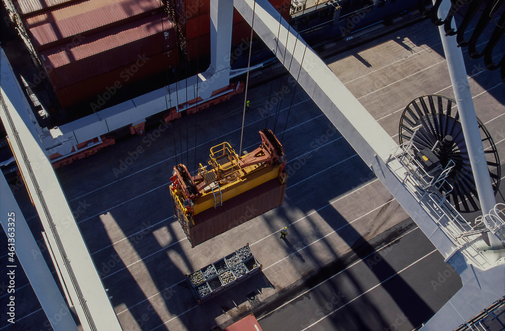 Looking down from crane at shipping container being hoisted for loading ...