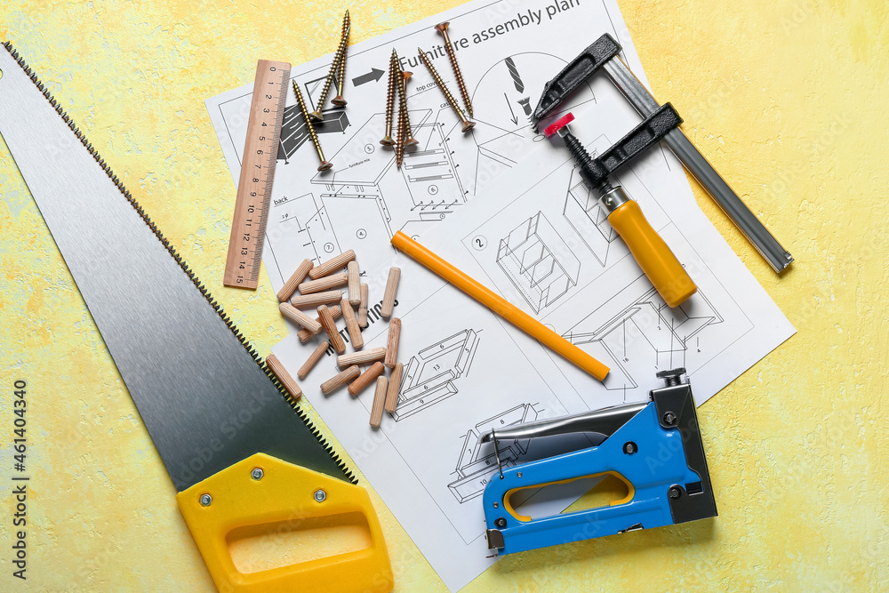 Furniture assembling instructions, plan and different tools on yellow ...