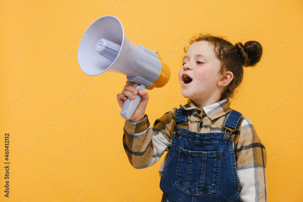 Emotional little girl kid shouting at copy space with megaphone, making ...
