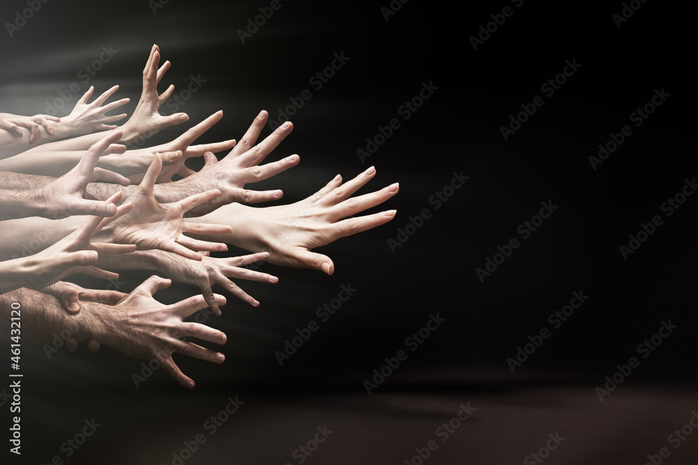 A lot of hands aggressively reaching forward. Black background. Copy ...