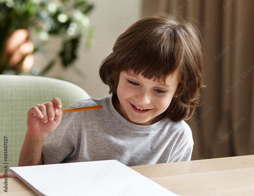 Foto de A cheerful little boy is solving math tasks and finding answers ...
