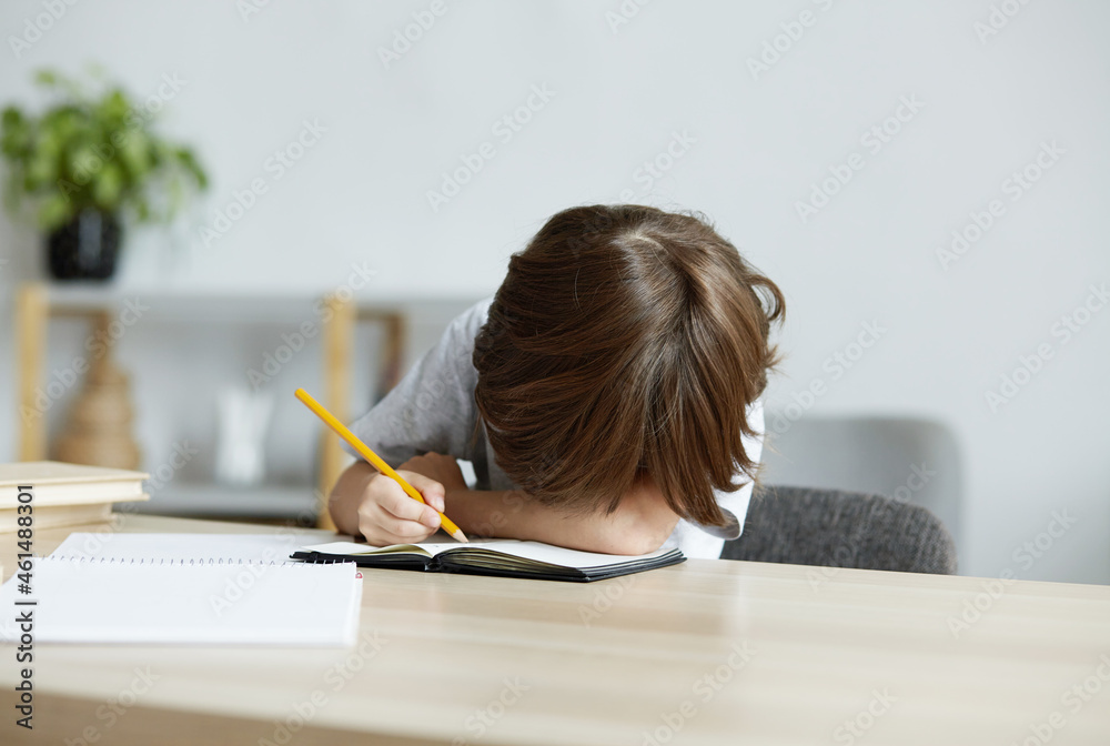 Exhausted school kid is tired from homework and learning and is lying ...