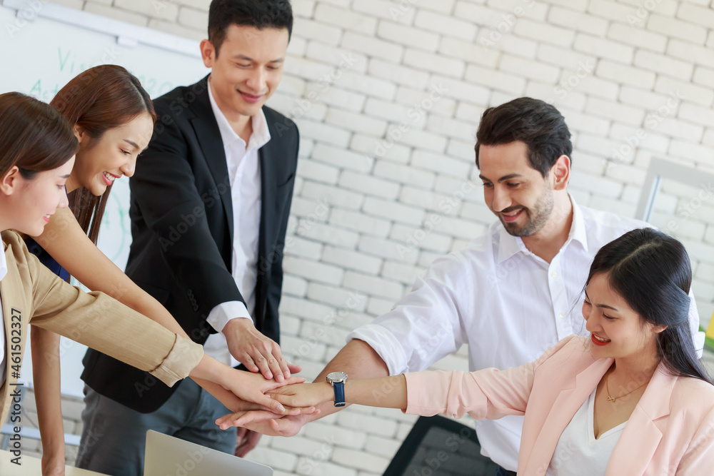 Diverse business people group put hands together in stack pile at training as concept of sales ...