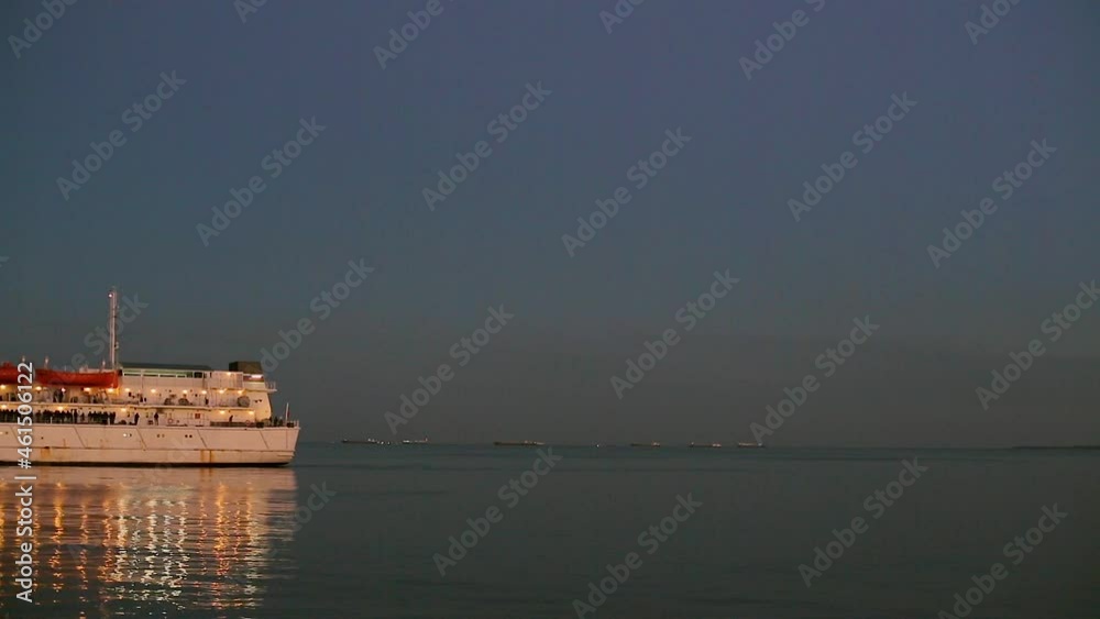 Cruise ship is sailing away at sunset. Seashore with the arrived ship ...