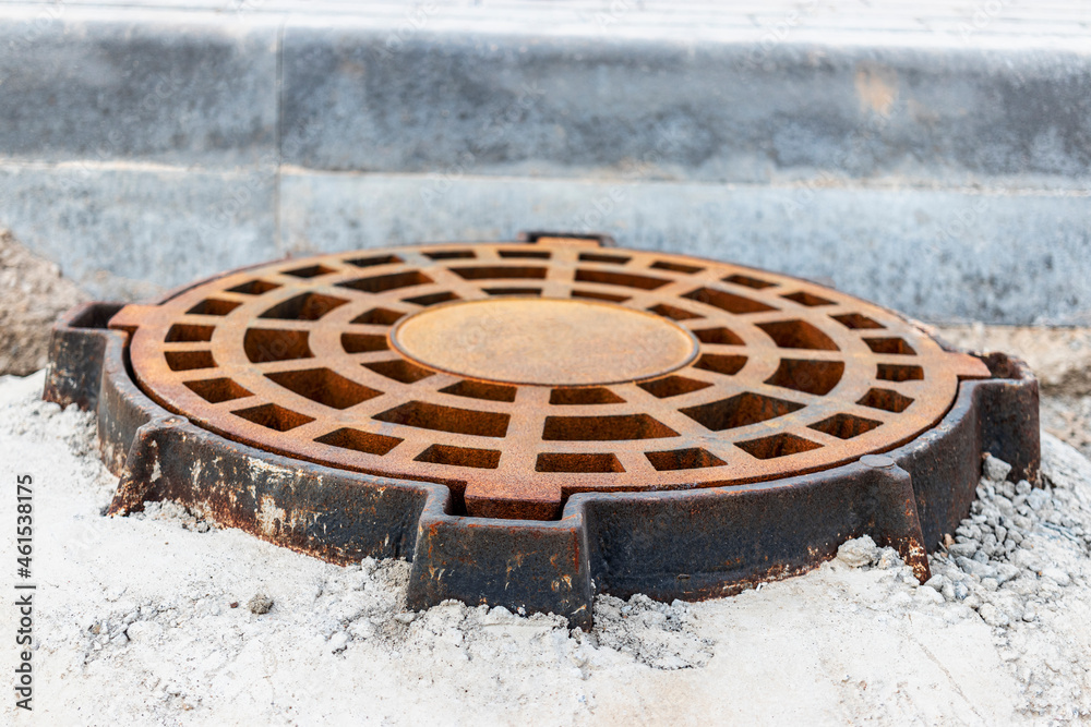 Cast-iron manhole of the storm sewer system on the road in front of the ...