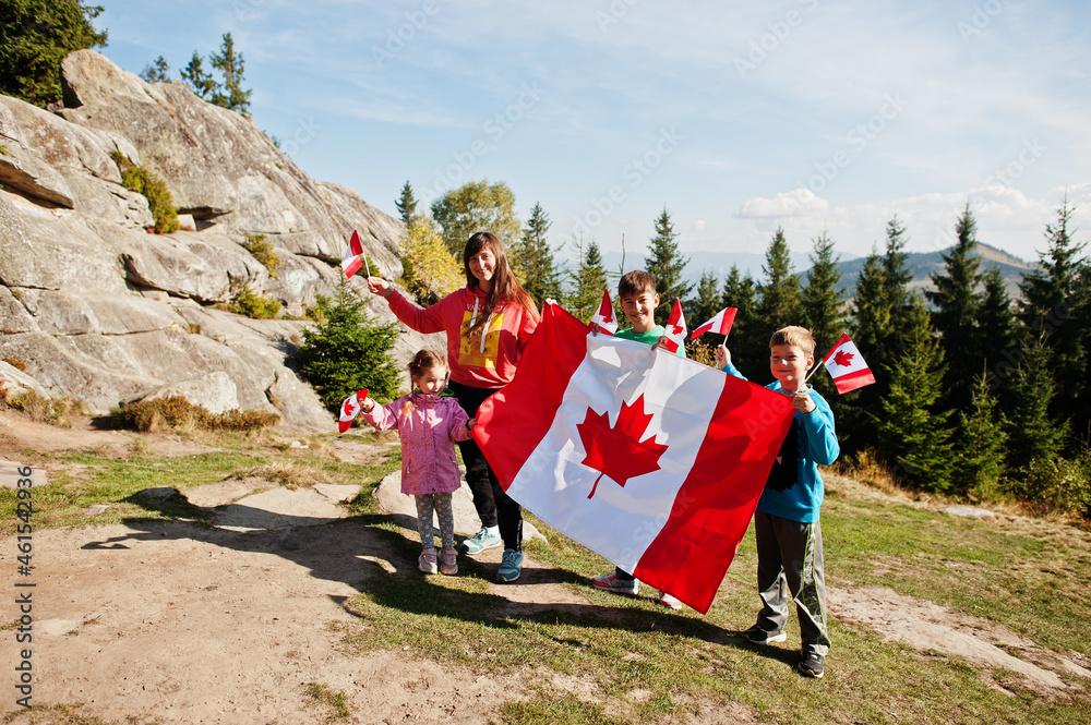 Happy Canada Day. Family of mother with three kids hold large Canadian ...