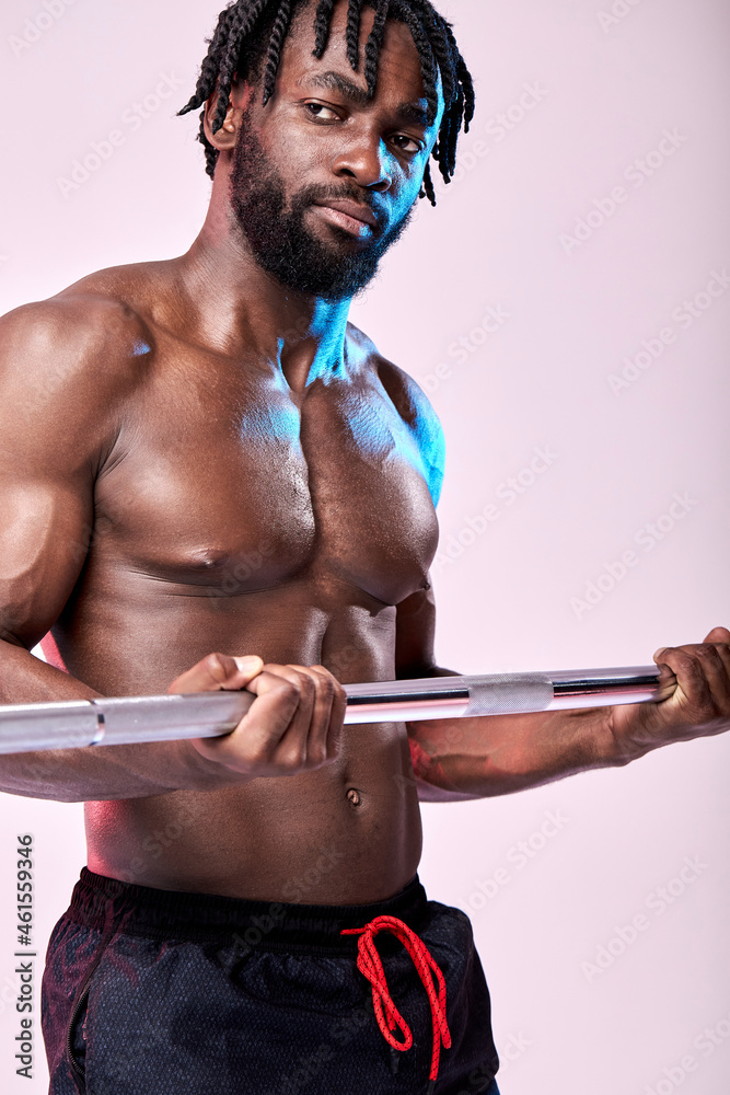 Handsome african male lifts weight showing power and strength ...