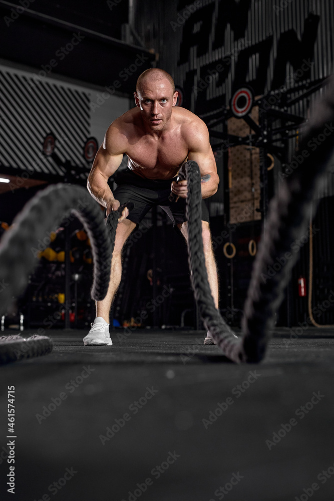 Waves of force. Young caucasian healthy bodybuilder training with ...