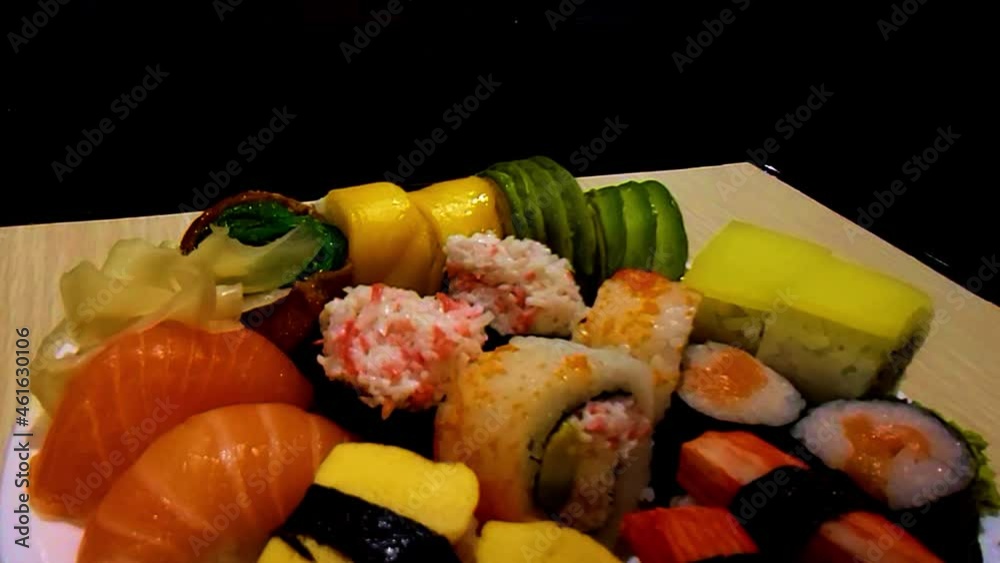 Assorted variation of sushi on a plate with a semi circle zoom into a ...