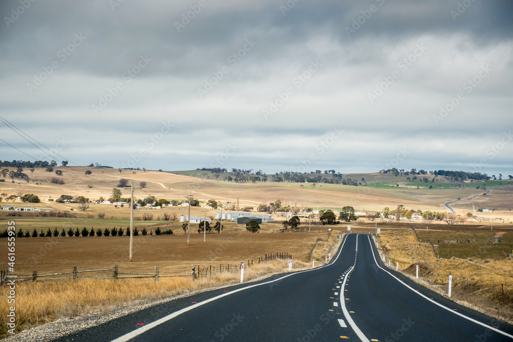 Straight open empty road surrounded by farms and fields in Bombala ...