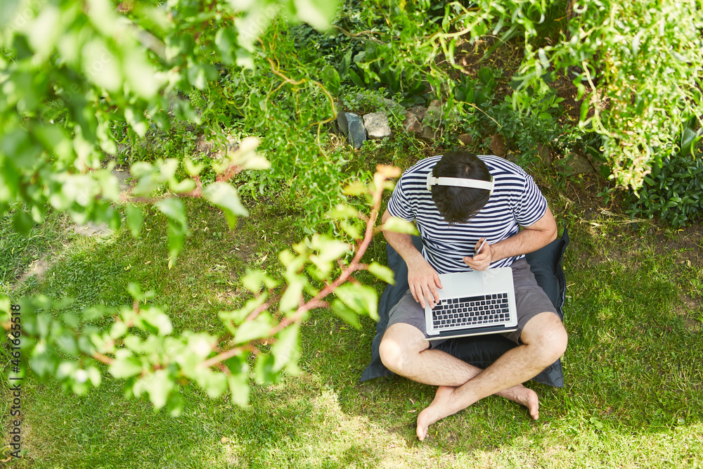 Man on laptop pc online in green garden Stock Photo | Adobe Stock