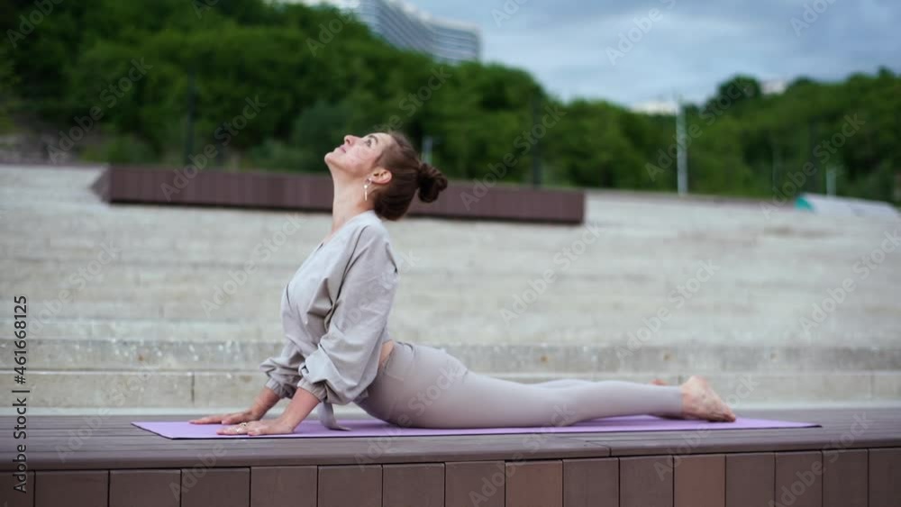 Front view of flexible young woman with sporty body doing yoga exercise ...